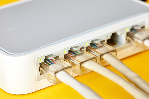 Kabel Ethernet Yang Terhubung Ke Desktop Switch Atau Papan Router Pada Latar Belakang Kuning