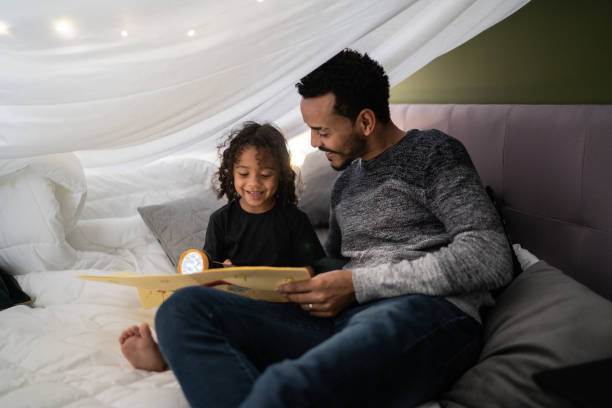 Free Stock Photo of Father and son reading book with flashlight ...
