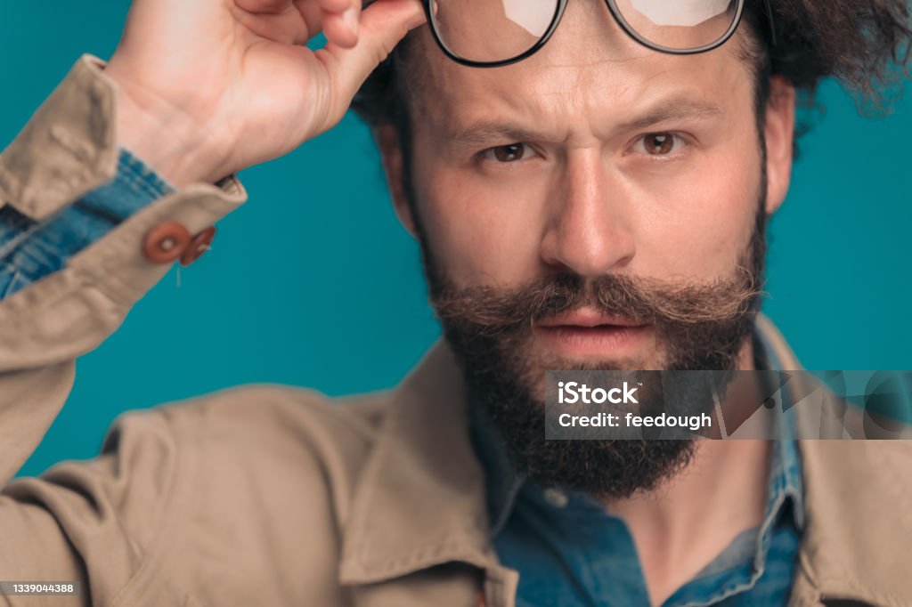 Close Up Of Serious Casual Man With Glasses On Forehead Frowning Stock