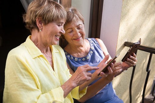 Temanteman Wanita Senior Yang Bahagia Menggunakan Smartphone Melihat ... Temanteman Wanita Senior Yang Bahagia Menggunakan Smartphone Melihat ...