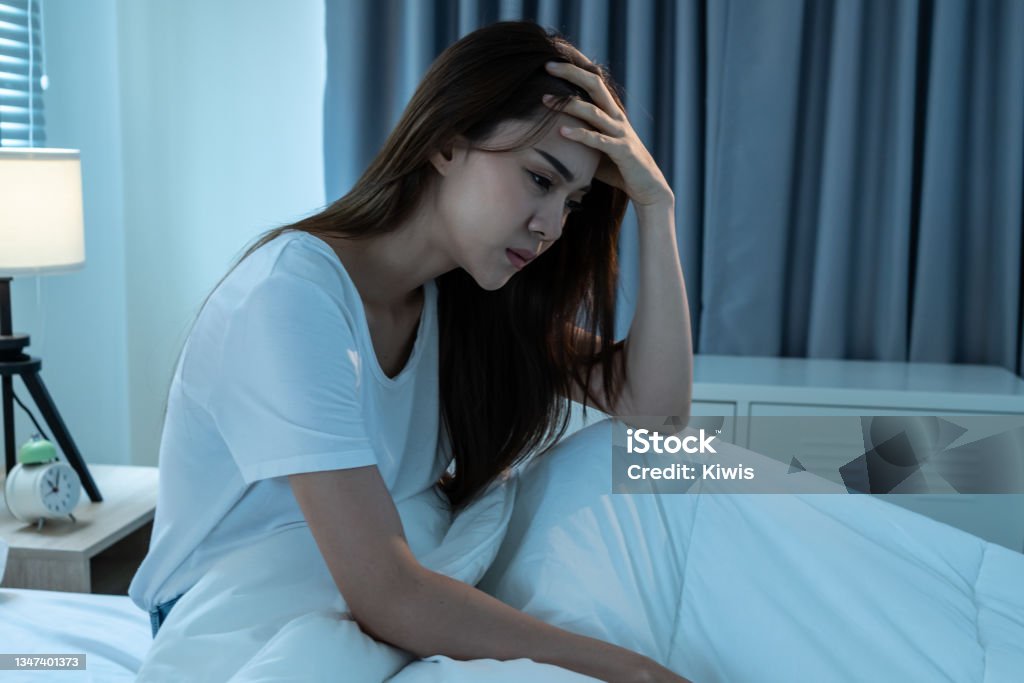 Asian Beautiful Upset Depressed Girl Sitting Alone On Bed In Bedroom