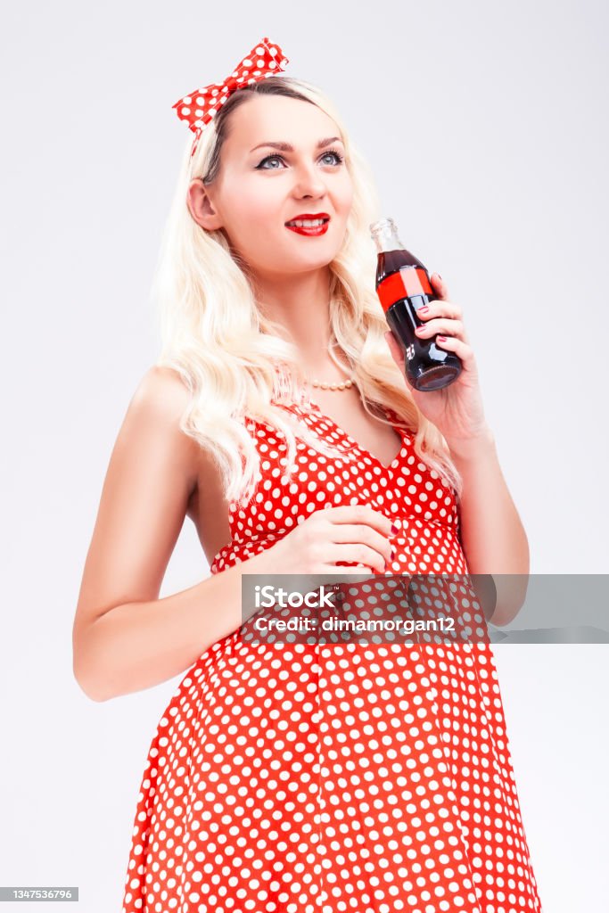 Portrait Of Smiling Blond Girl In Pinup Style Posing With Bottle Of