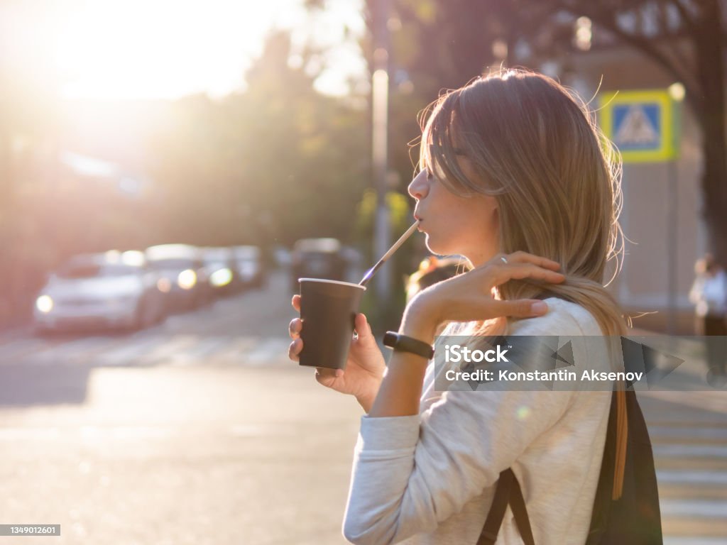 Woman With Curly Hair And Eyeglasses Drinks Cappuccino With Straw
