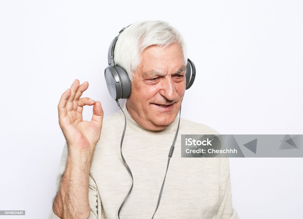 Happy Old Man In Headphones Listening To Music On White Background