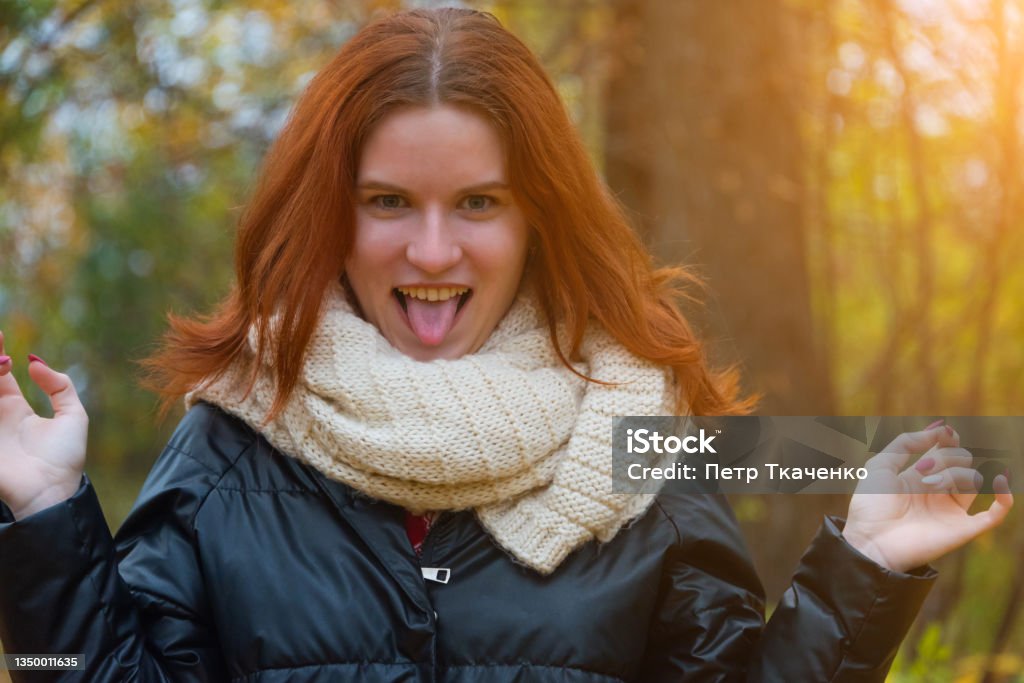 A Portrait Of A Redhaired Smiling Girl In A Jacket And Scarf Shows Her