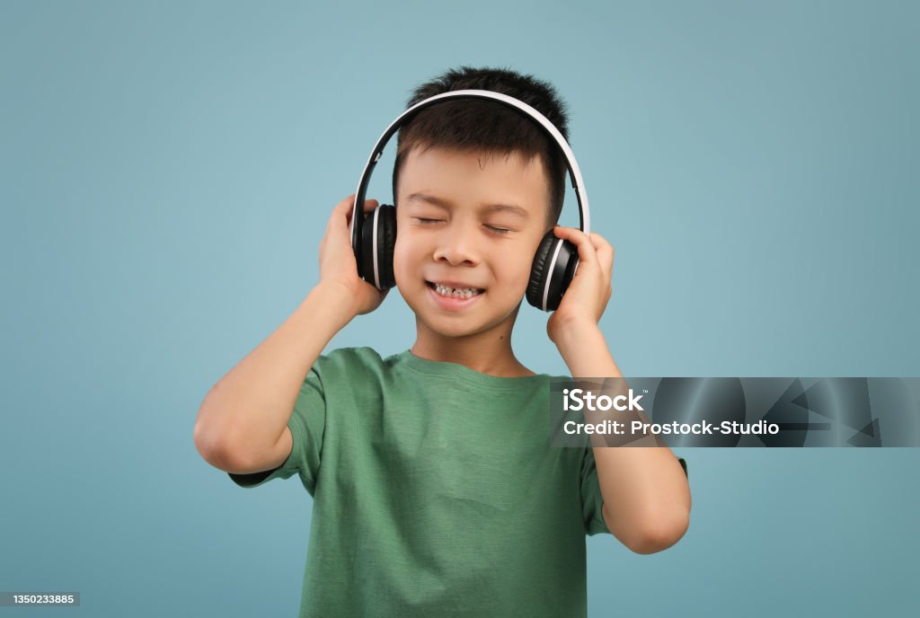 Anak Lakilaki Asia Kecil Yang Ceria Mendengarkan Musik Di Headphone ... Anak Lakilaki Asia Kecil Yang Ceria Mendengarkan Musik Di Headphone ...