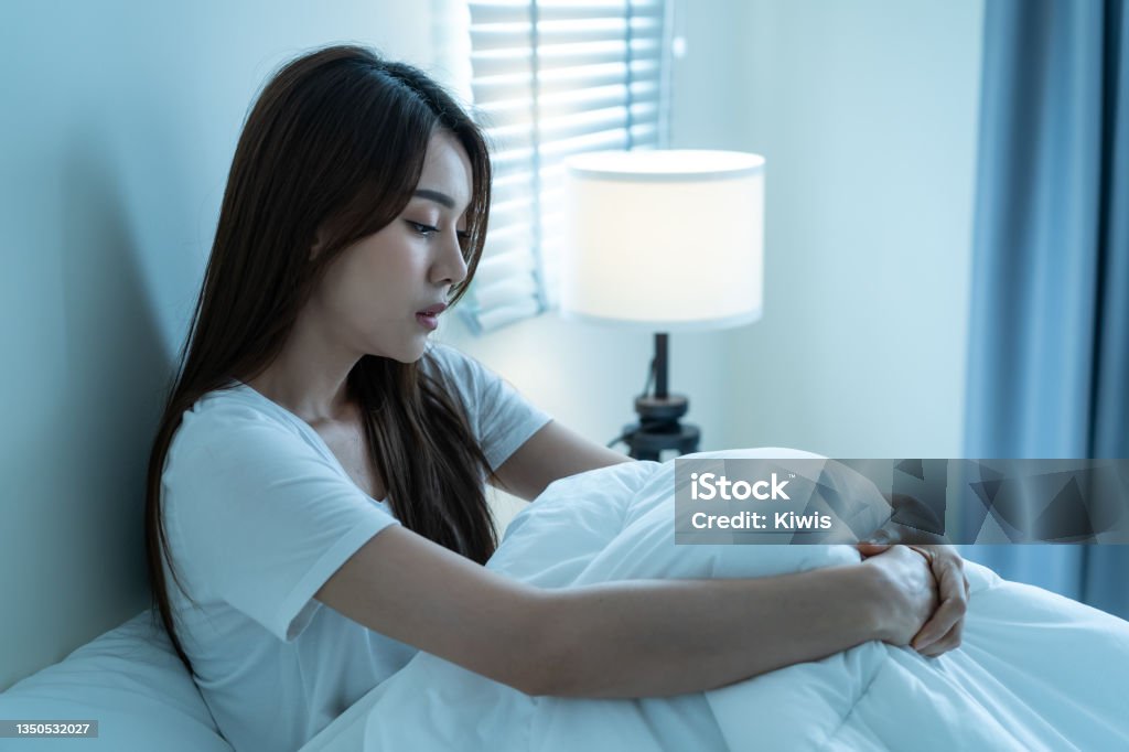 Asian Beautiful Upset Depressed Girl Sitting Alone On Bed In Bedroom