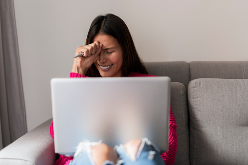 Woman Works At Home By Distancing Herself From The Sofa In Her Living ... Woman Works At Home By Distancing Herself From The Sofa In Her Living ...