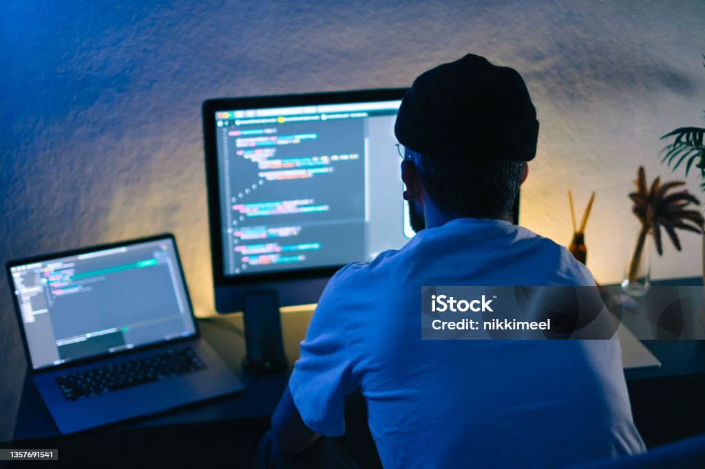 Young Man Mobile Developer Writes Program Code On A Computer Programmer