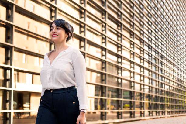 Free Stock Photo of Woman Walking Down Sidewalk Next to Tall Building ...