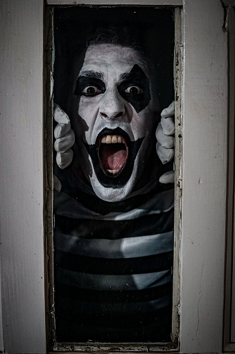 Vertical Terrifying Shot Of A Male In A Mime Costume Posing In Horror