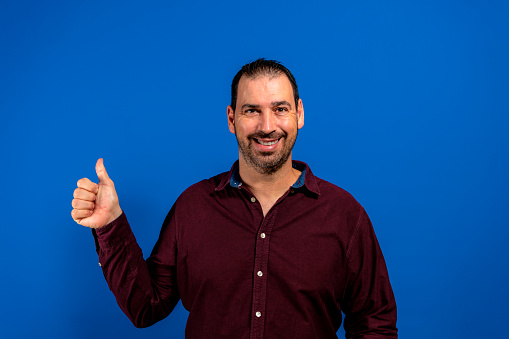 Portrait Of Cheerful Man In Basic Clothing Smiling And Showing Thumbs