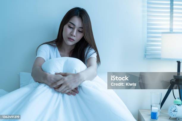 Asian Beautiful Upset Depressed Girl Sitting Alone On Bed In Bedroom