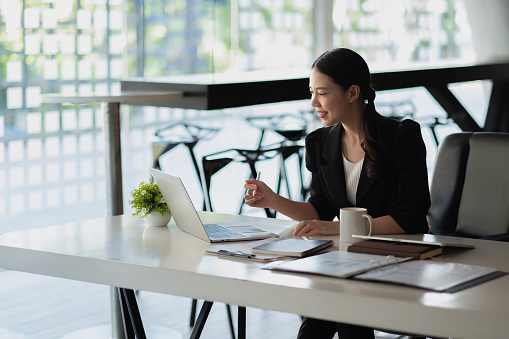 Pengusaha Asia Yang Menawan Duduk Bekerja Di Laptop Di Kantor Bidikan ... Pengusaha Asia Yang Menawan Duduk Bekerja Di Laptop Di Kantor Bidikan ...