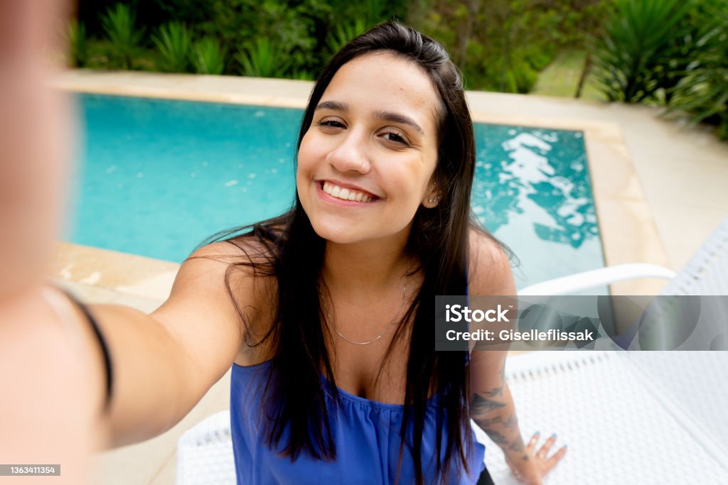 Beautiful Woman Taking Selfie In Front Of A Swimming Pool At Resort
