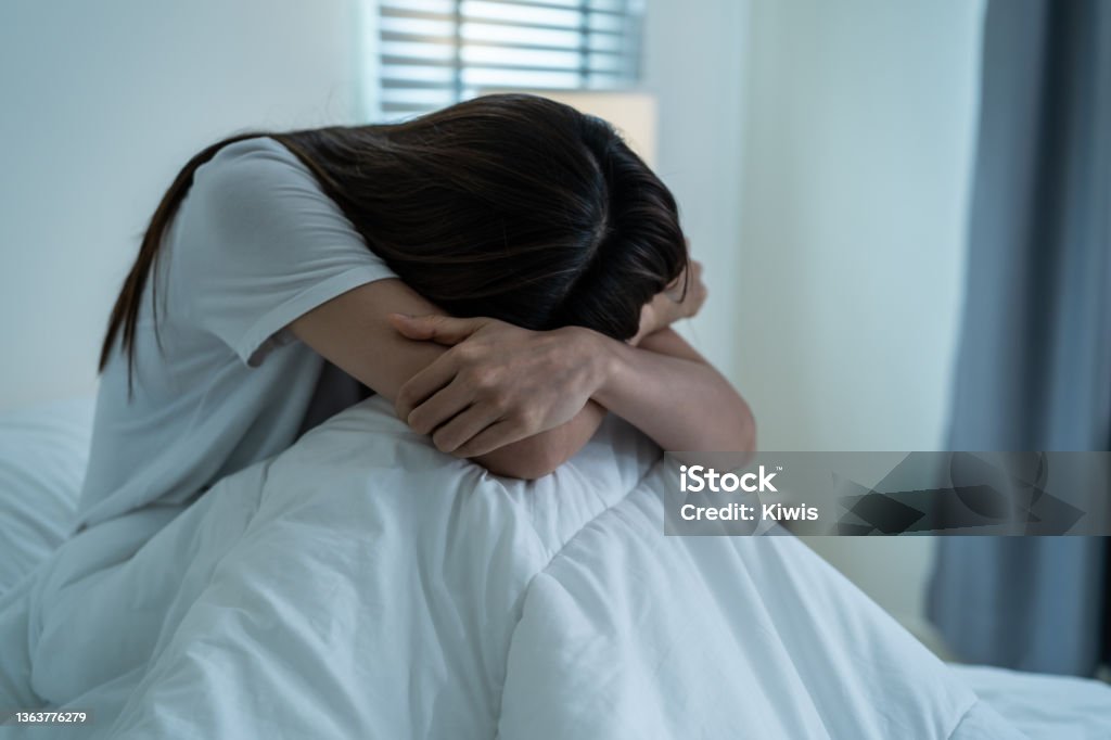 Asian Beautiful Upset Depressed Girl Sitting Alone On Bed In Bedroom