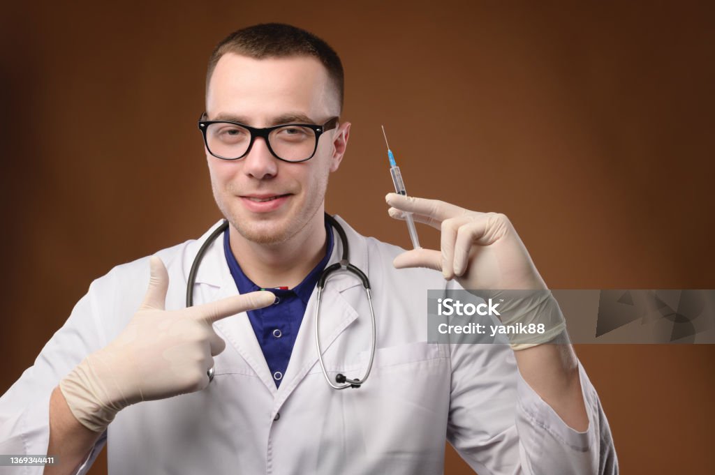 Seorang Dokter Kaukasia Muda Dengan Mantel Putih Dan Kacamata Memegang ... Seorang Dokter Kaukasia Muda Dengan Mantel Putih Dan Kacamata Memegang ...