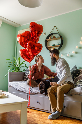 Young Man Surprising His Girlfriend With Heart Shaped Balloons On