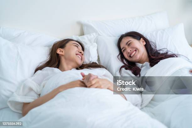 Asian Beautiful Lesbian Couple Lying On Bed And Looking At Each Other