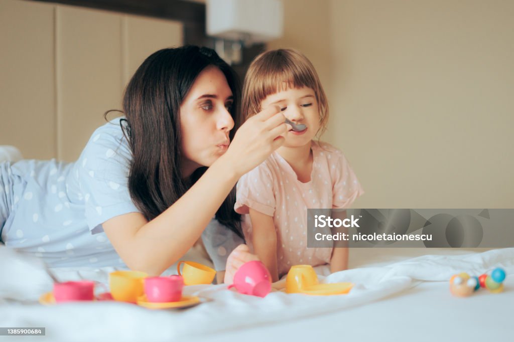 Funny Mother And Daughter Having A Playpretend Pajama Party In Bed