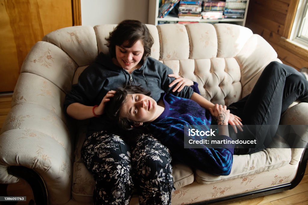 Lesbian Couple Enjoying Simple Pleasures At Home Cuddling On The Sofa