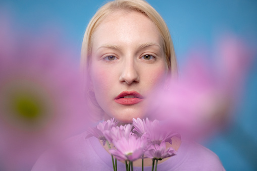 Portrait Of A Woman Expressing Her Femininity Over Blue Background