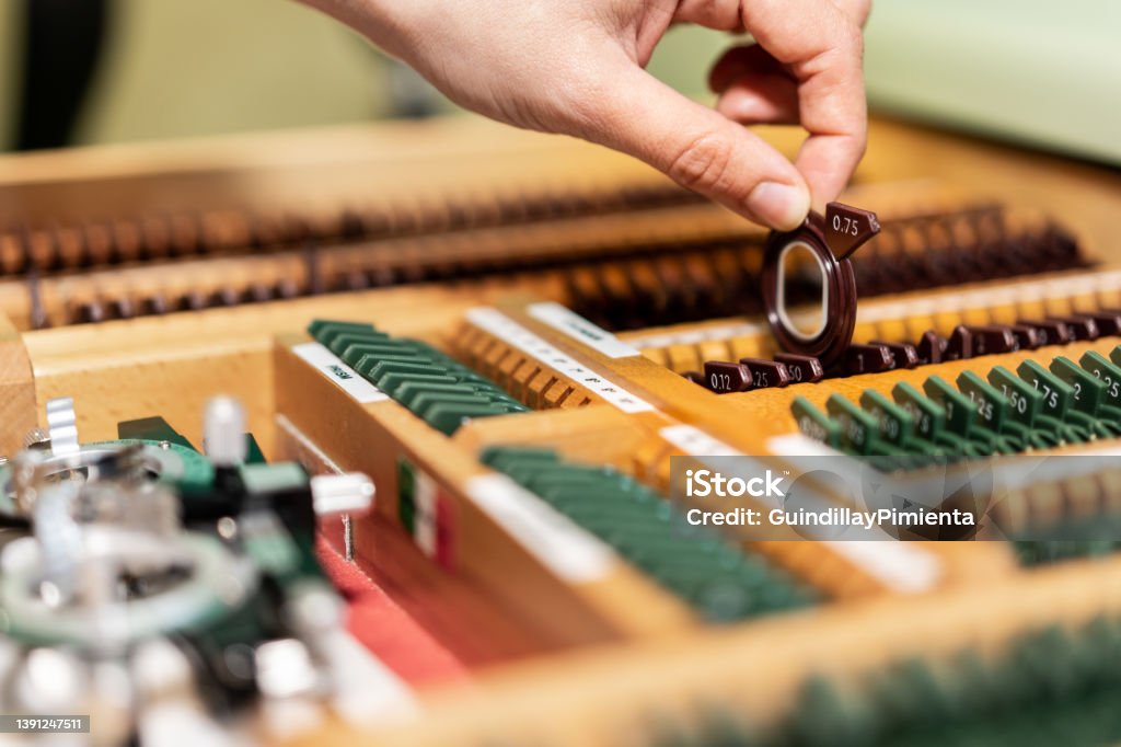 Optician Hands Choosing Lenses From Set Of Corrective Lens Indicating