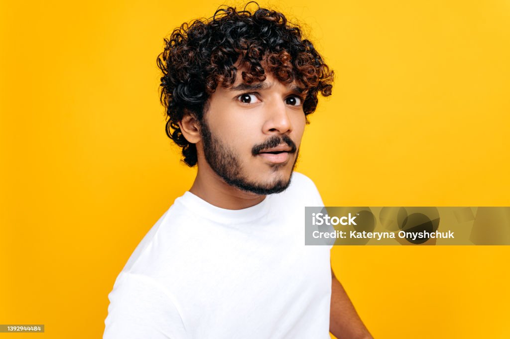 Close Up Of Confused Puzzled Curly Haired Indian Or Arabian Guy In