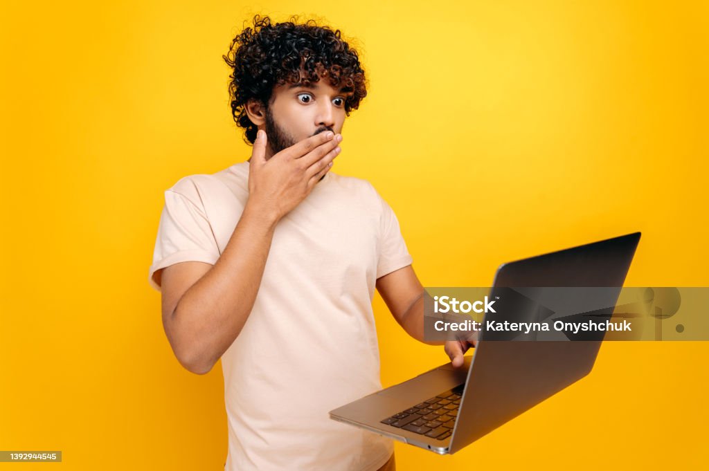 Confused Amazed Shocked Indian Or Arabian Curlyhaired Guy Holding An