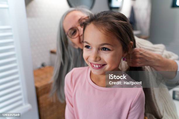 Senior Grandmother And Granddaughter Standing Indoors In Bathroom Daily