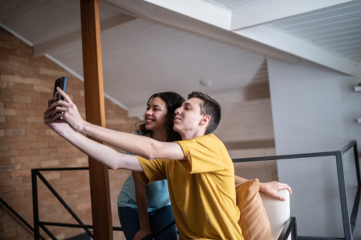 Siblings Taking Selfies Or Filming It Using Mobile Phone At Home Stock