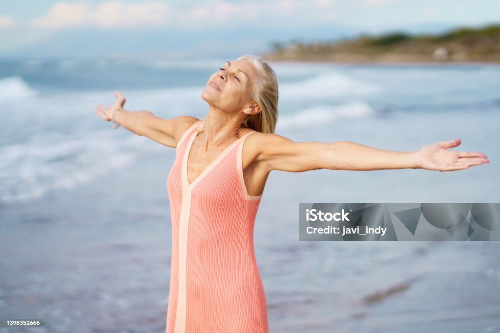 Beautiful Older Female Spreading Her Arms On A Beautiful Beach Spending