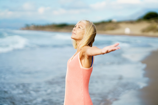 Beautiful Older Female Spreading Her Arms On A Beautiful Beach Spending