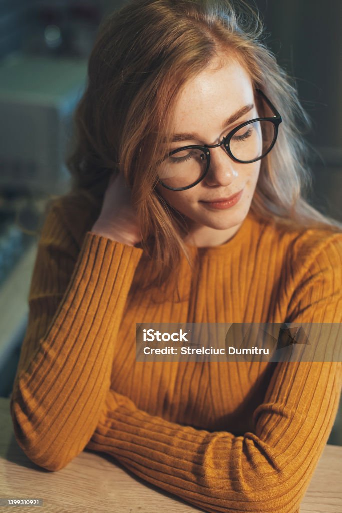 Closeup Portrait Of A Redheaded Woman Wearing Glasses Sitting At Home