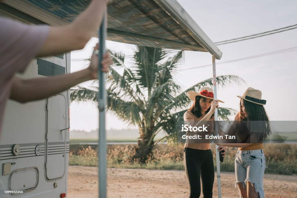 Asian Chinese Lesbian Couple And Gay Friend Setting Up Awning Canopy Of