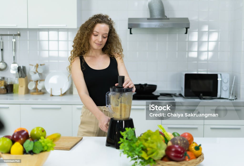 Smart Vegetarian Woman Cooking Healthy Vegetable And Fruit Juice In