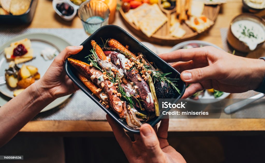 Unrecognizable Friends Sharing Food During A Dinner Celebration Stock