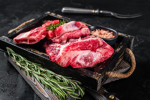 Raw Organic Beef Short Ribs Ready To Cook In Wooden Tray With Herbs Black Background Top View