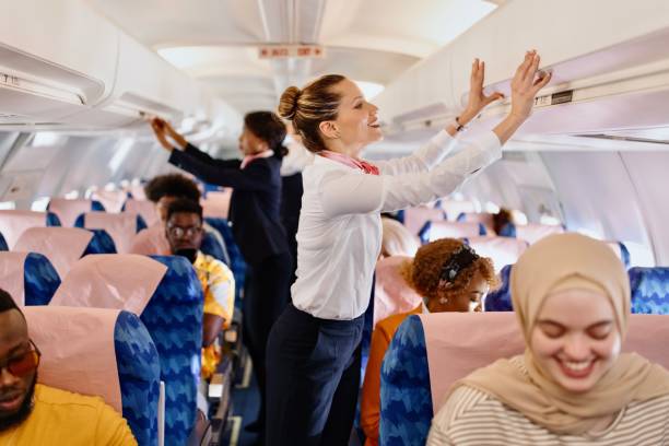 Free Stock Photo of Flight attendant checks the passenger overhead ...