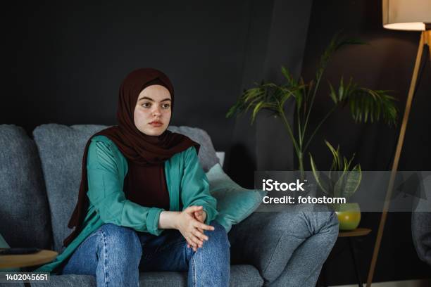 Wanita Muda Yang Putus Asa Duduk Di Sofa Tangan Tergenggam Merenung ... Wanita Muda Yang Putus Asa Duduk Di Sofa Tangan Tergenggam Merenung ...