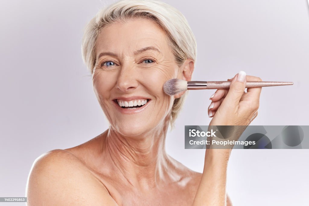 Portrait Of A Smiling Mature Caucasian Woman Posing With A Makeup Brush