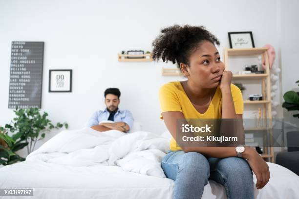 Depressed Young Man Sitting On Bed And Having Problems With His