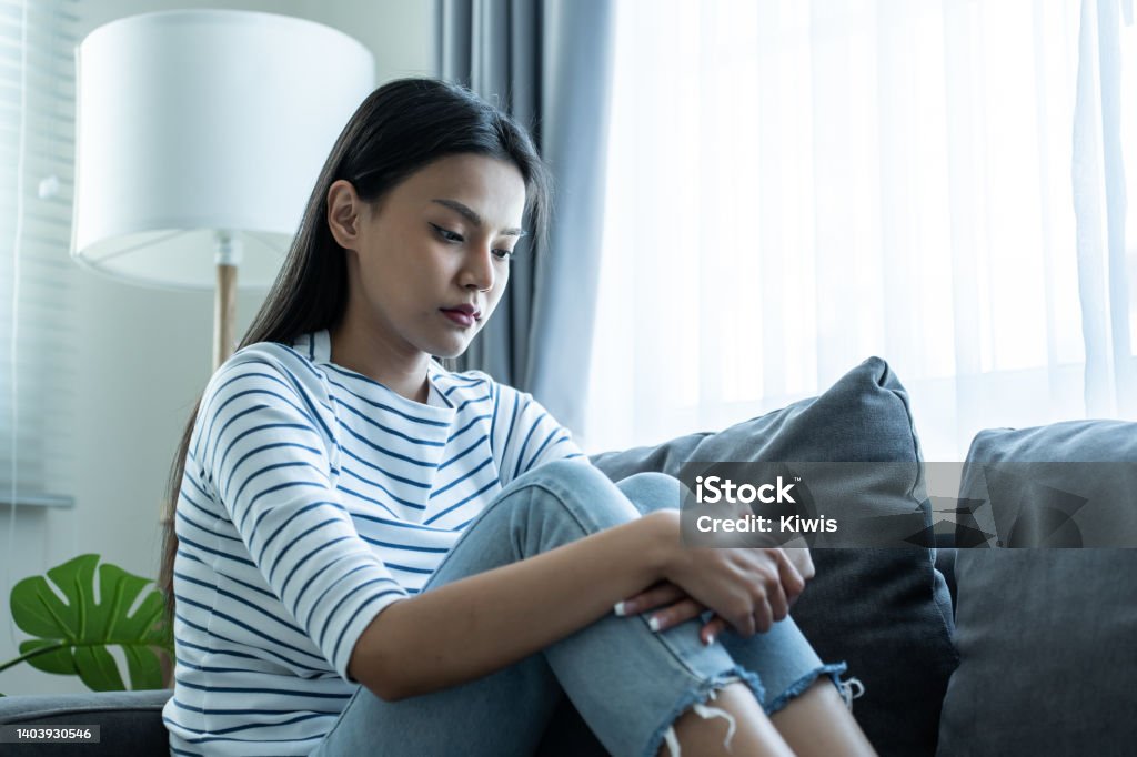 Asian Beautiful Upset Depressed Girl Sitting Alone On Bed In Bedroom