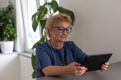 Photo Libre De Droit De Femme Âgée Utilisant Une Tablette Numérique À