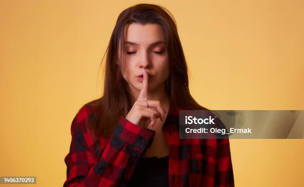 Wanita Muda Menunjukkan Tanda Diam Dan Melihat Kamera Yang Mengenakan