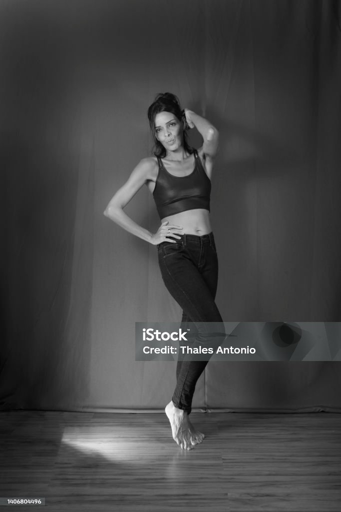 Black And White Portrait Of Adult Model Standing Against Dark Green