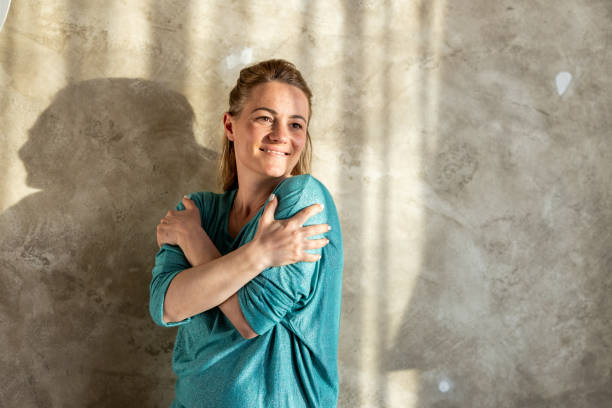 Free Stock Photo of Woman embraces herself against concrete wall ...