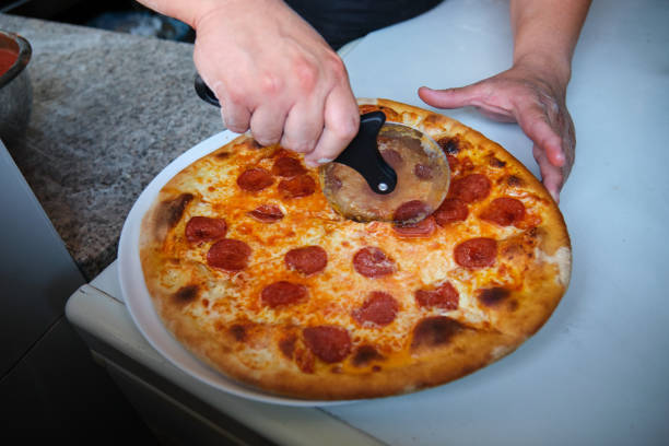 Free Stock Photo of Person cutting a pizza topped with olives and ...