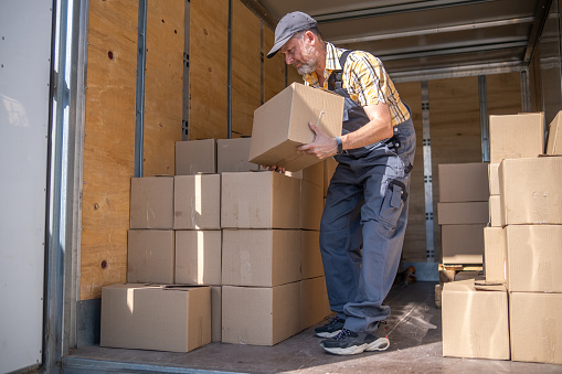 A Cheerful Worker Unloads Cartons Of Goods Stock Photo - Download Image ... A Cheerful Worker Unloads Cartons Of Goods Stock Photo - Download Image ...