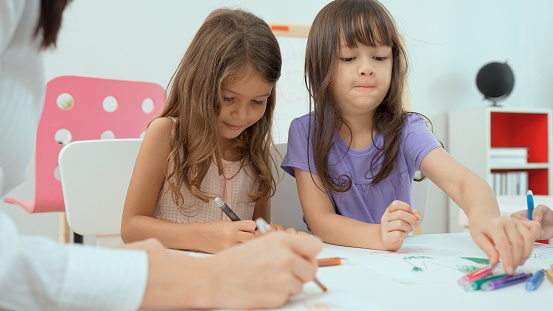 Guru Perempuan Mengajar Gadis Kecil Untuk Melukis Buku Berwarna Di Atas